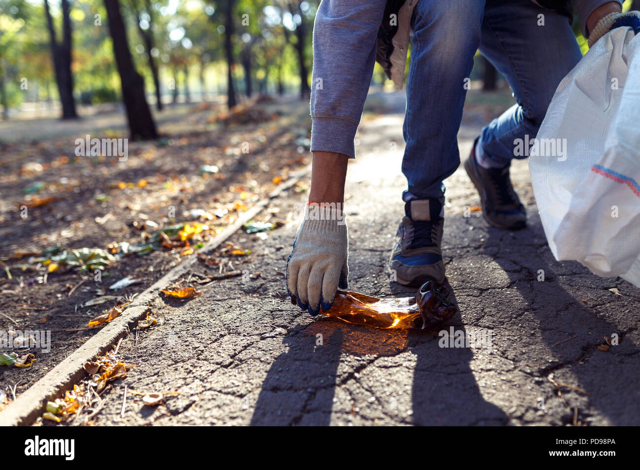 young man picking up trash outdoor. close up Stock Photo - Alamy