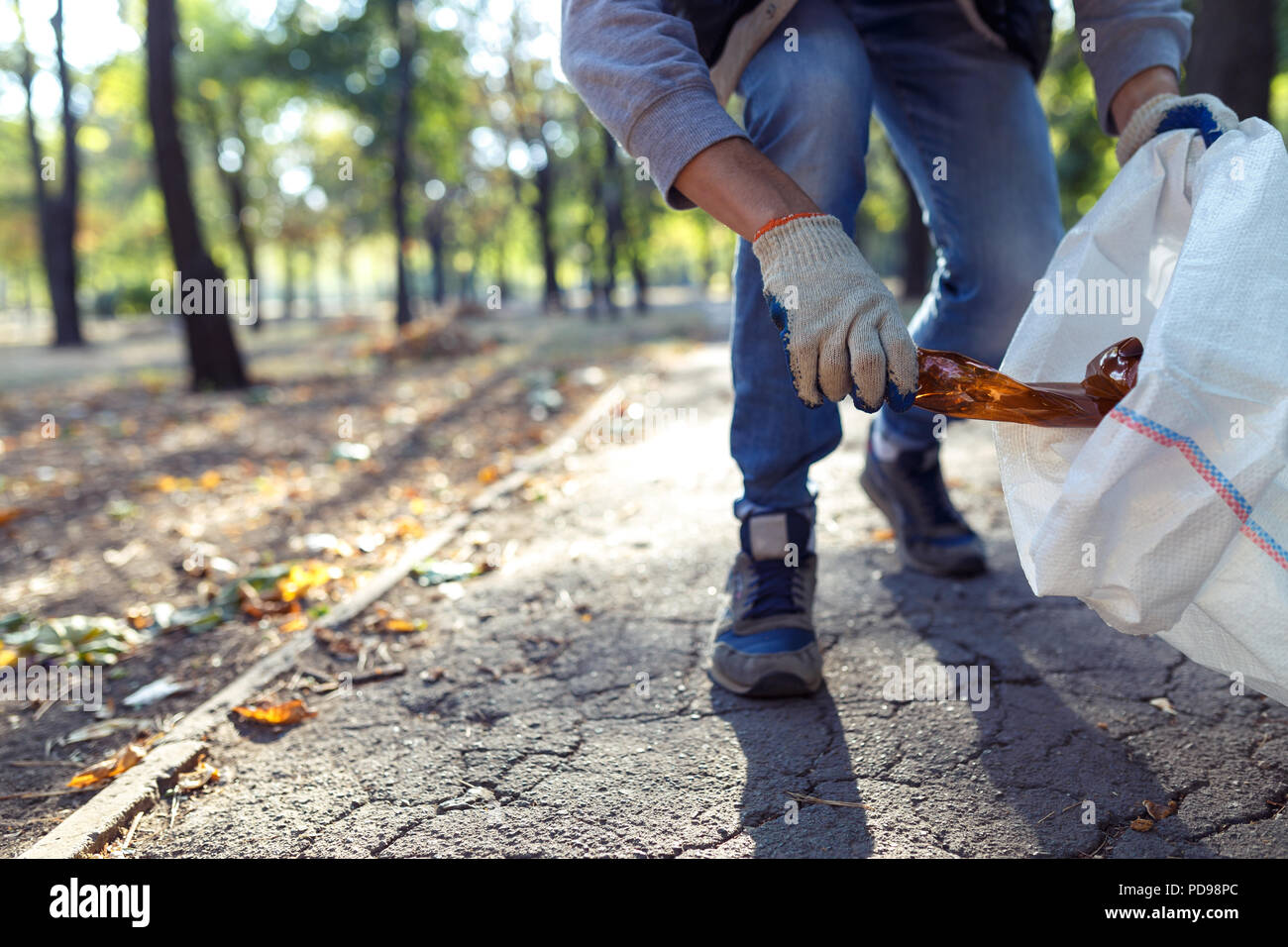 young man picking up trash outdoor. close up Stock Photo - Alamy