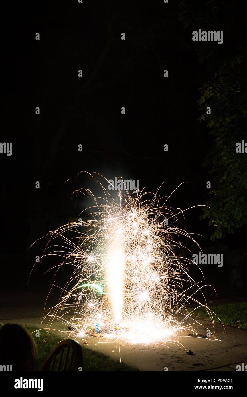 Ground spark shower fireworks or firecrackers in home driveway at night ...