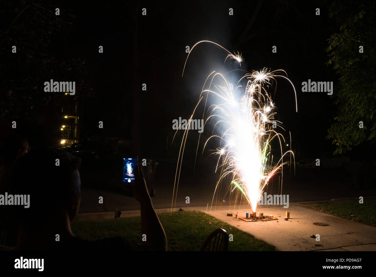 Ground spark shower fireworks or firecrackers in home driveway at night ...