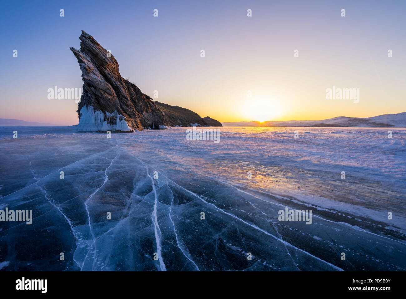 Lake Baikal during warm sunrise in winter. Beautiful rocks and crack ...