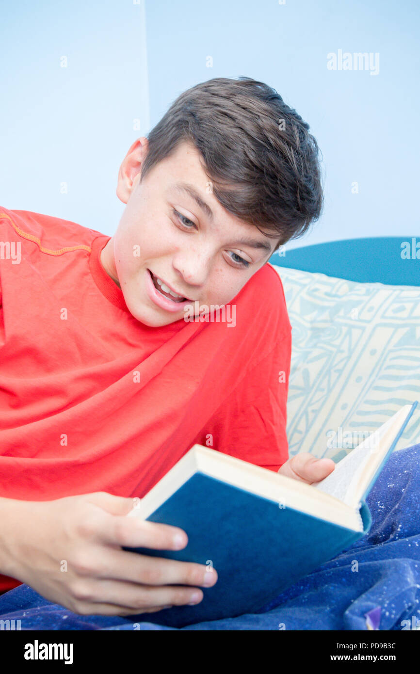 Boy laughing reading book hi-res stock photography and images - Alamy
