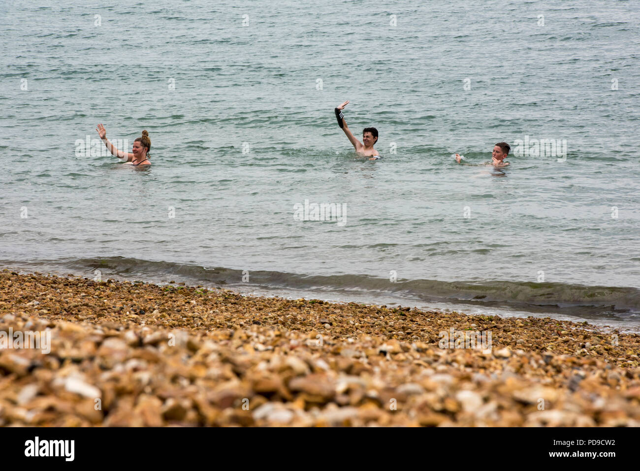 three people swimming in the sea Stock Photo - Alamy