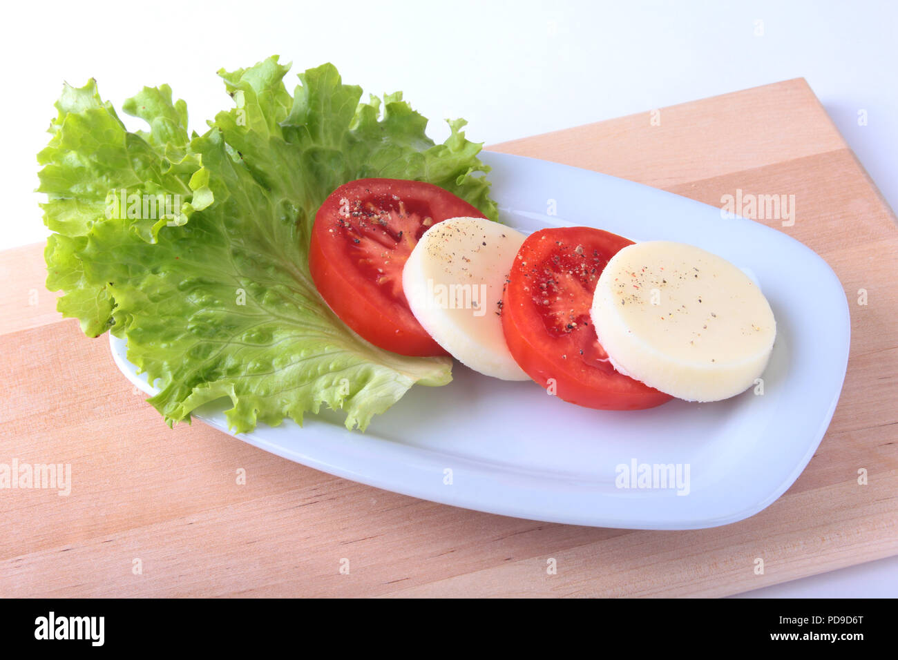 Portion of Mozzarella with Tomatoes, lettuce leaf and Balsamic dressing ...