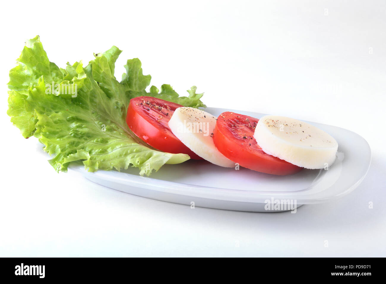 Portion of Mozzarella with Tomatoes, lettuce leaf and Balsamic dressing ...