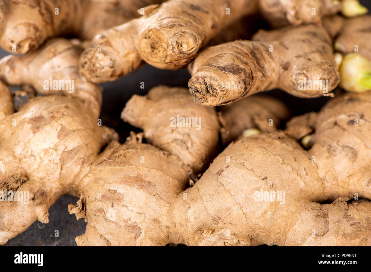 Whole ginger roots on dark old stone background table top view space ...