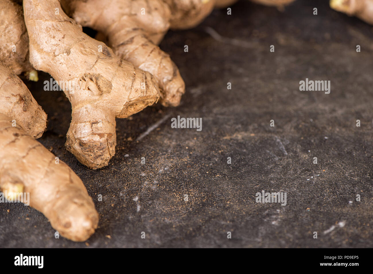 Whole ginger roots on dark old stone background table top view space ...