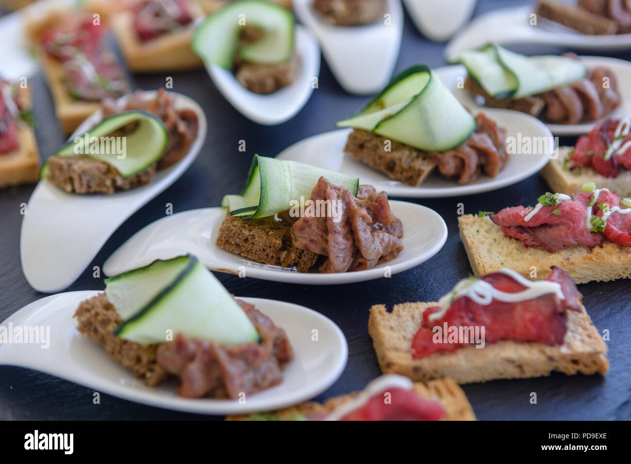 Finger food served on black stone plate with brown bread and toasted ...