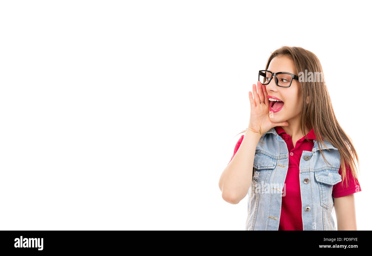 Young woman in red shirt and denim jacket holding hand near mouth ...