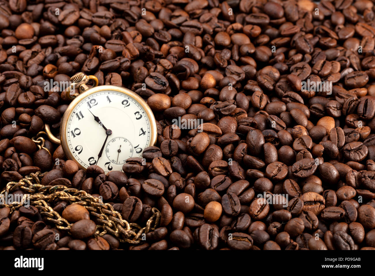 a lot of coffee beans with an old hand watch, conceptual photo ...