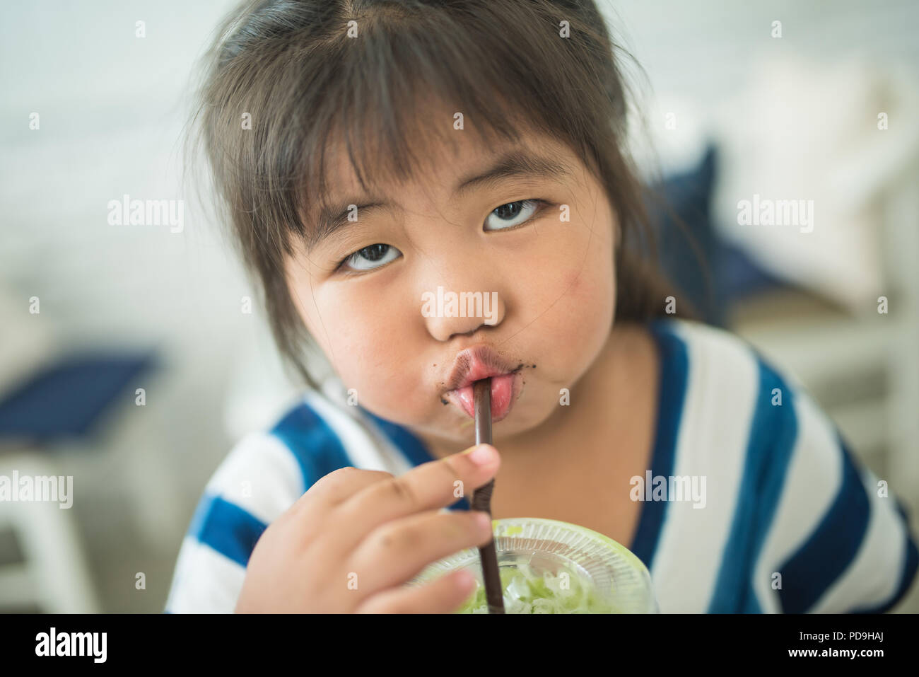 A cute asian girl drinking green tea with funny face Stock Photo - Alamy