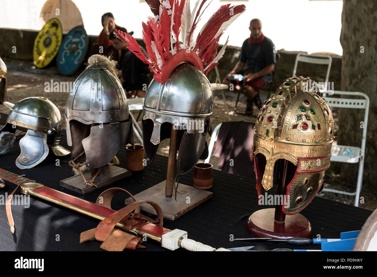 A row of Roman soldier helmets and a sword on display during a history ...