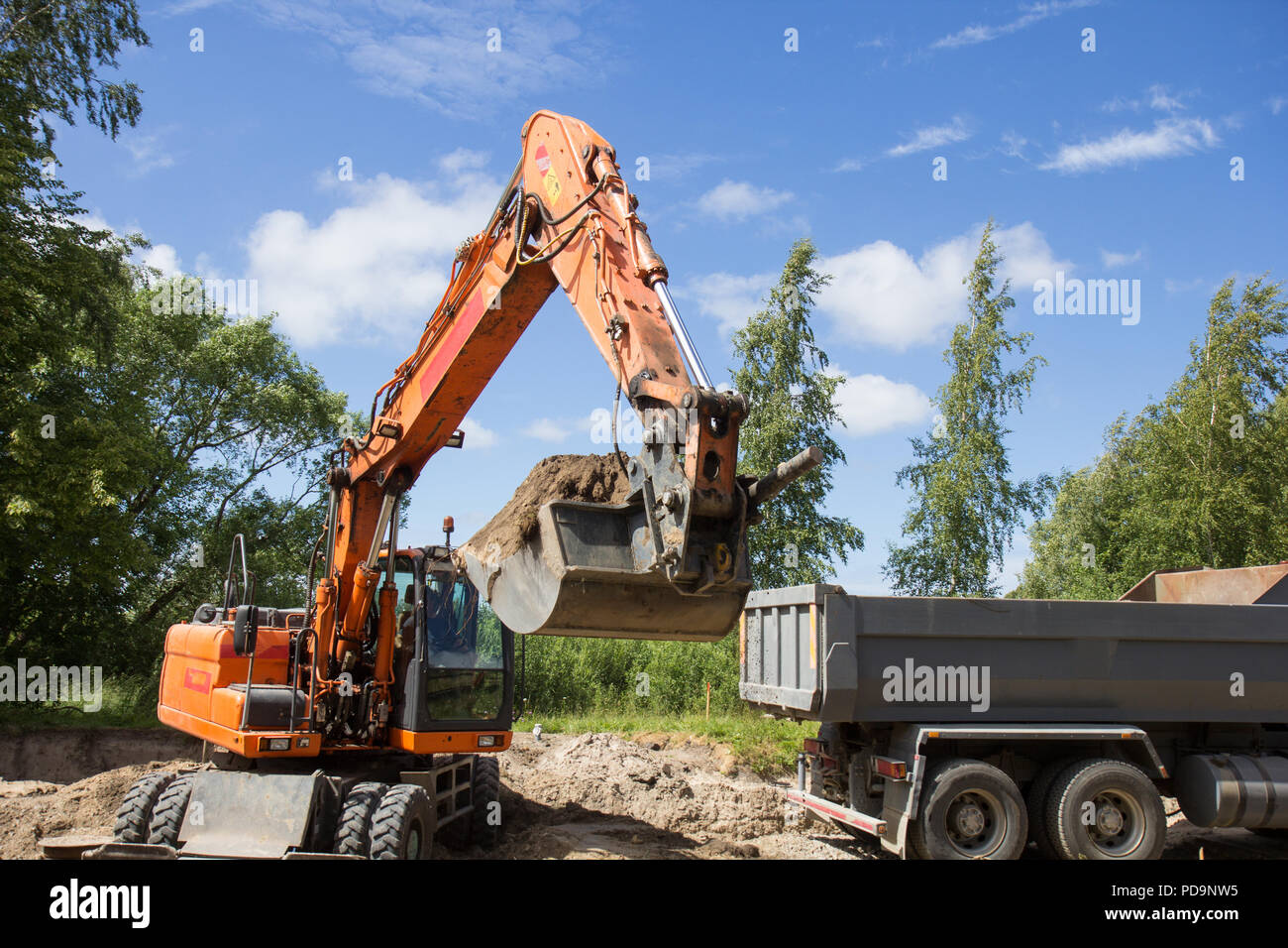 excavator loading ground to tipper truck on the street reconstruction ...