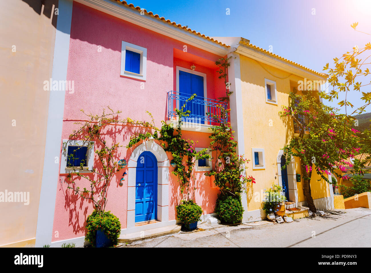 Assos village. Traditional colored greek houses with bright blue doors ...