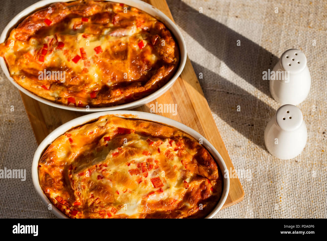 Two trays with baked omelette made from cheese, eggs, ham and red ...