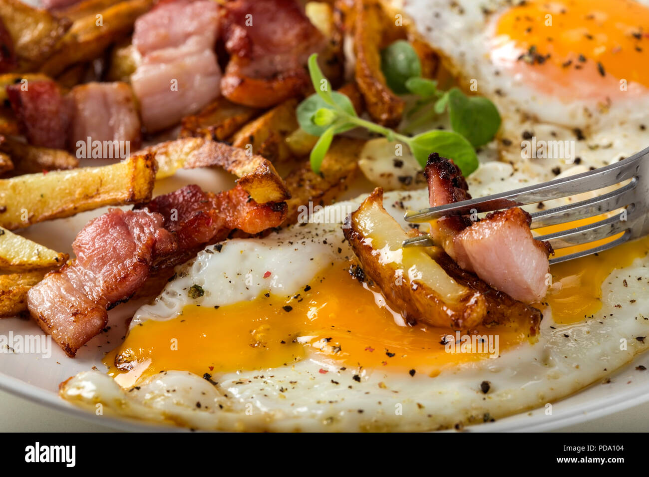 Homemade eggs with French fries and fried bacon on plate - close up ...