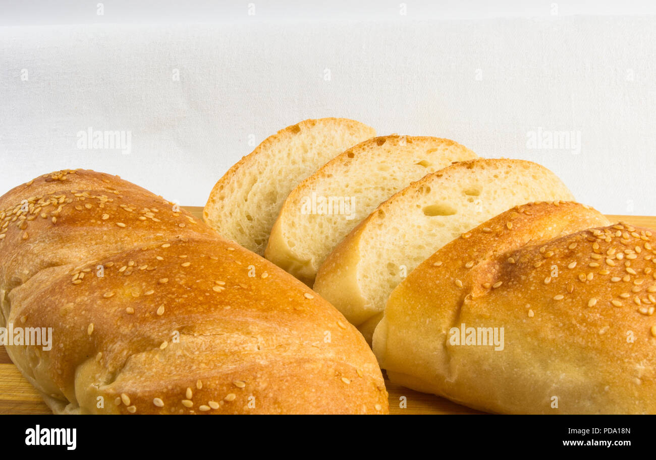 sliced whole wheat breads on a chopping Board against a white linen ...