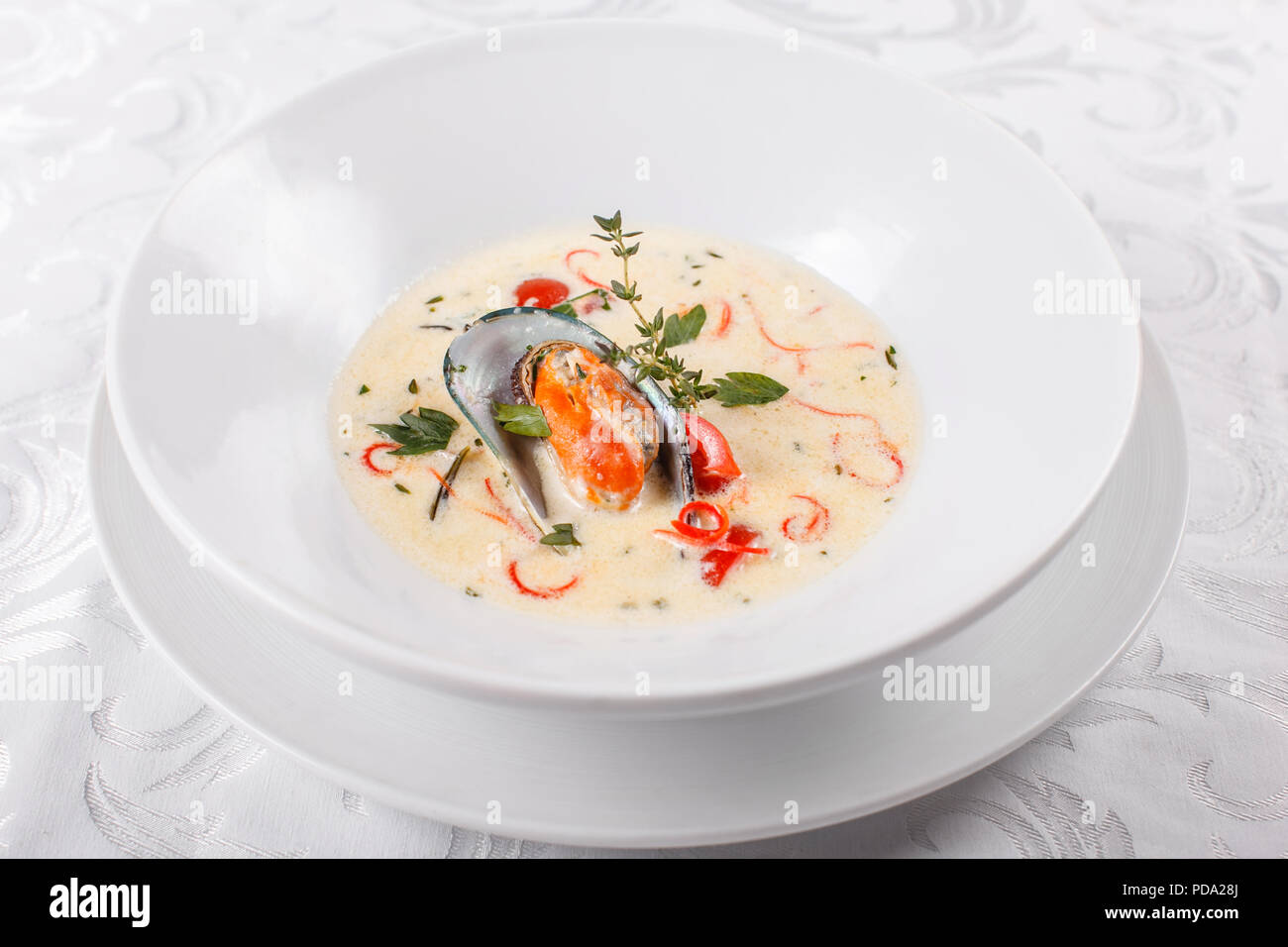 Cream soup with seafood, grilled prawns, mussels in a shell ...