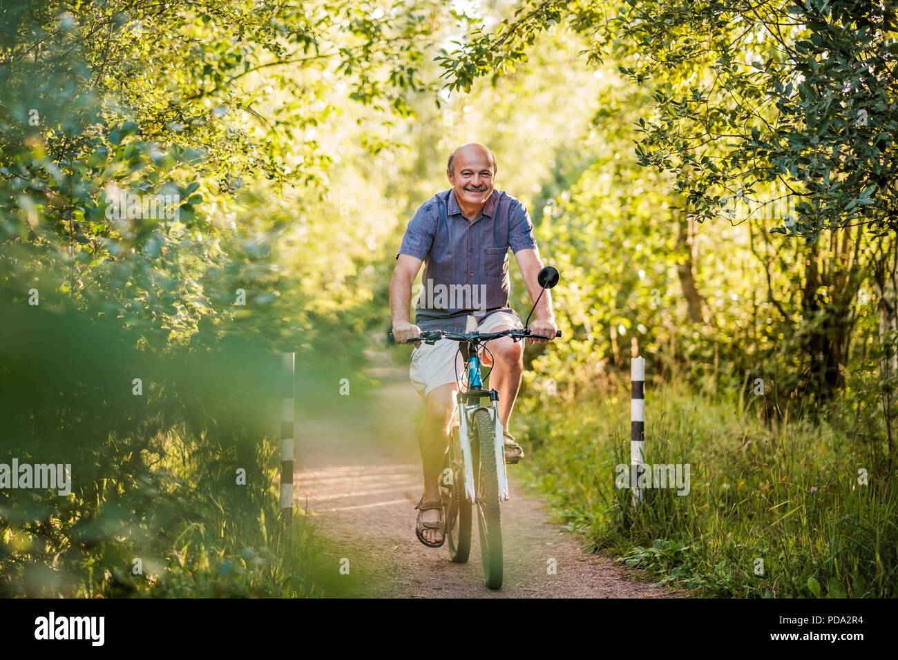 Old man riding bike on grass hi-res stock photography and images - Alamy
