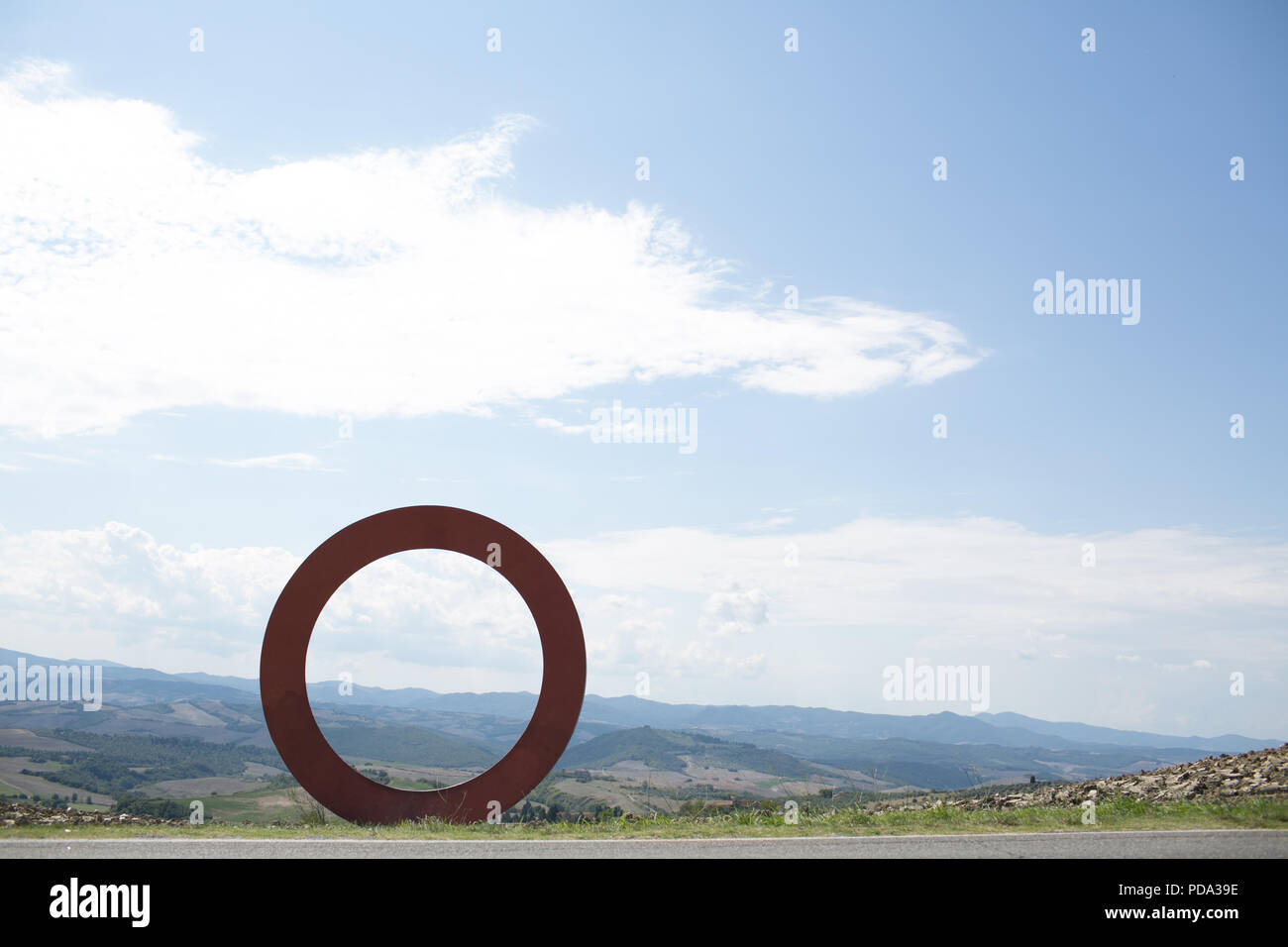 Large red circle sculpture by Mauro Staccioli near the roadside on the ...