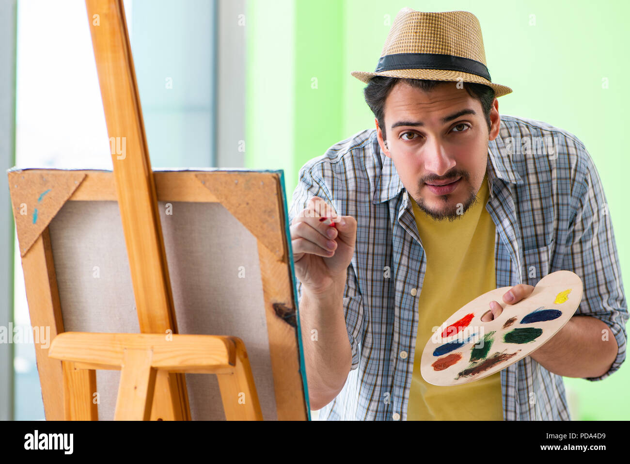 Young male artist working on new painting in his studio Stock Photo - Alamy