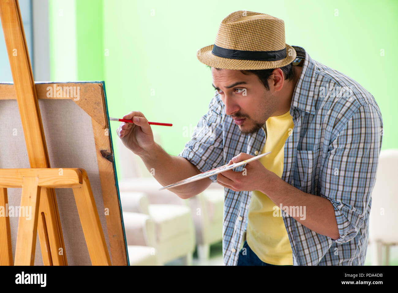 Young male artist working on new painting in his studio Stock Photo - Alamy