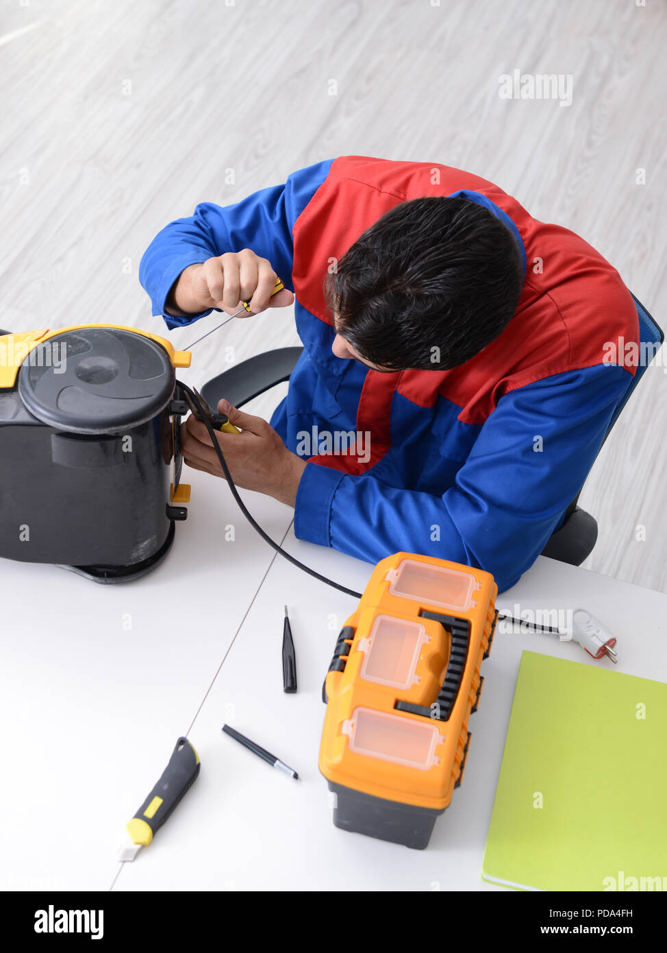 Man repairman repairing vacuum cleaner at service center Stock Photo ...
