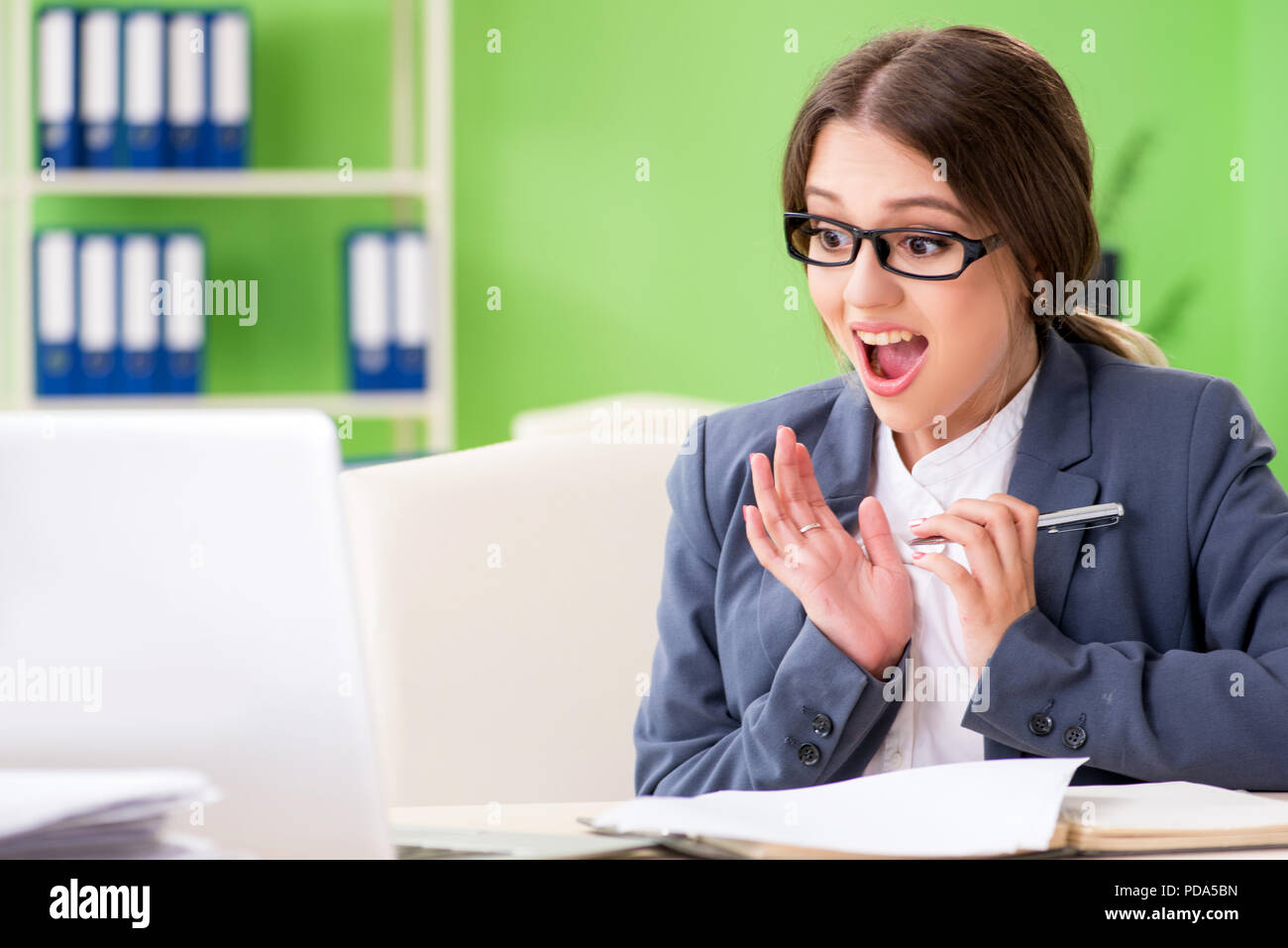 Young female employee very busy with ongoing paperwork Stock Photo - Alamy
