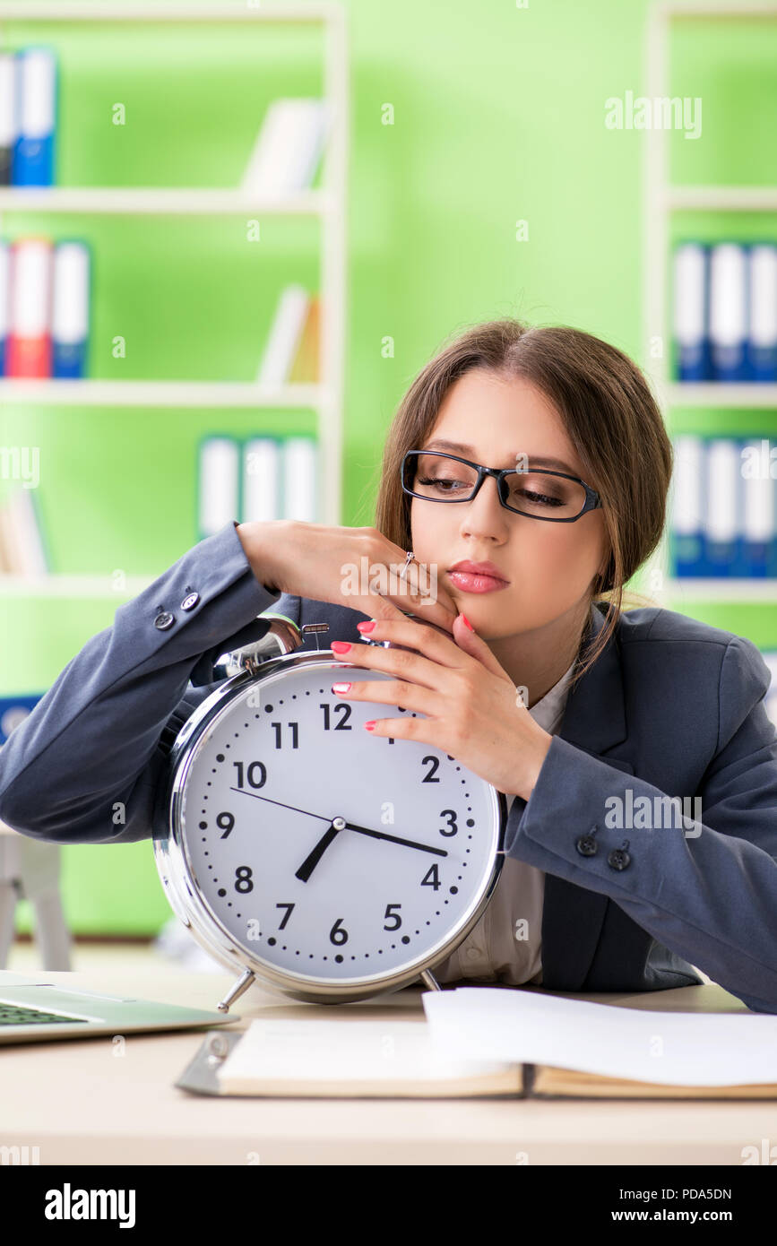 Young female employee very busy with ongoing paperwork in time ...