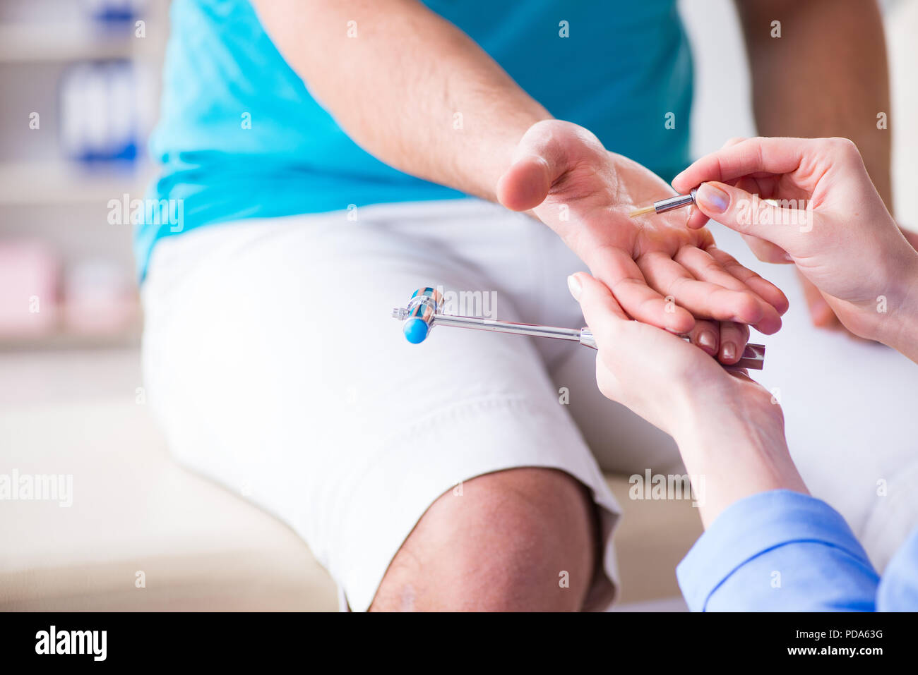 Doctor checking nerve reflexes with hammer Stock Photo - Alamy