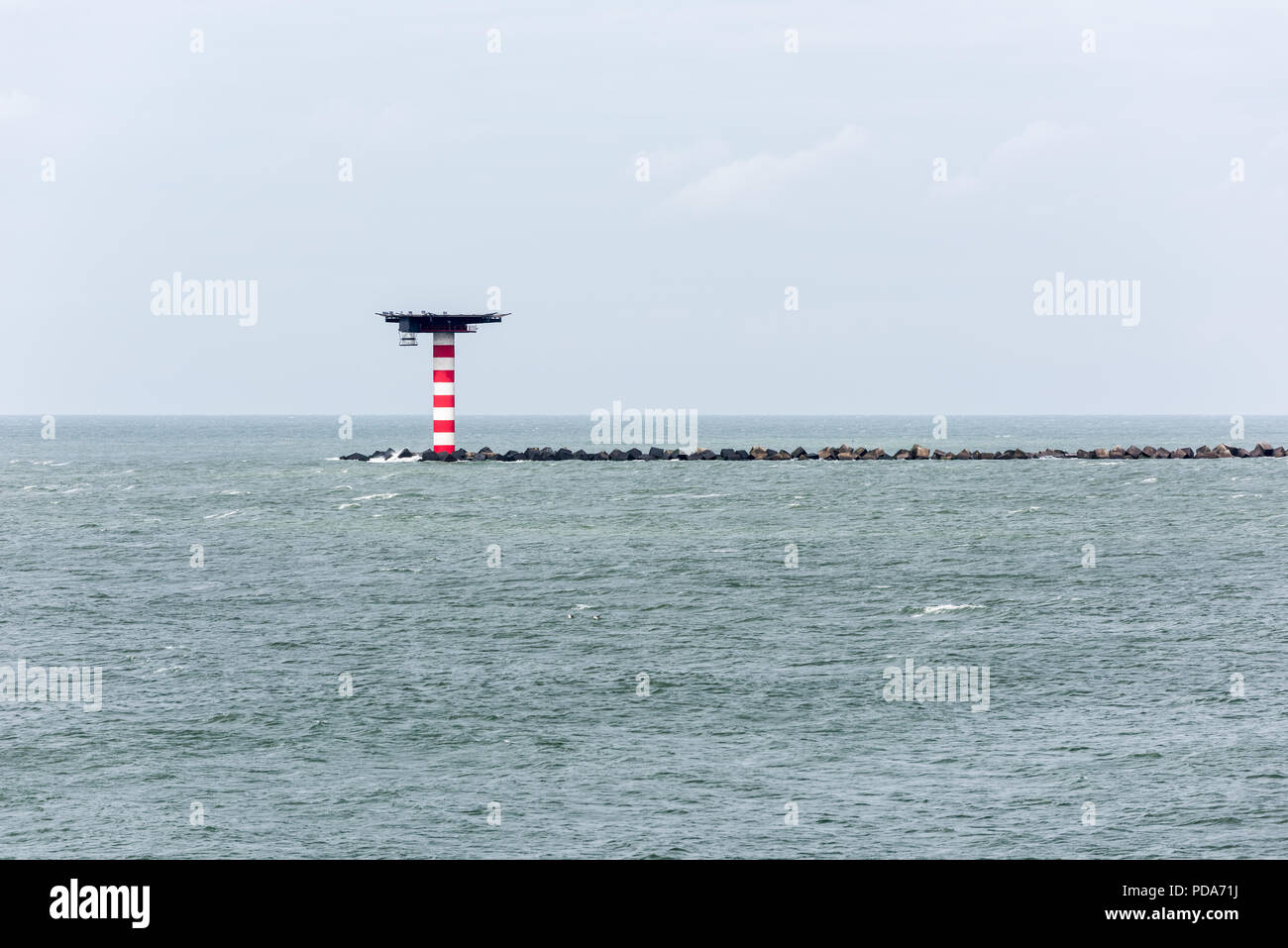 The red and white striped lighthouse with heliplatform at the entrance ...