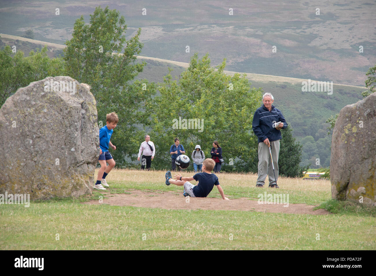 Children playing football and soccer using stones for goal posts with ...