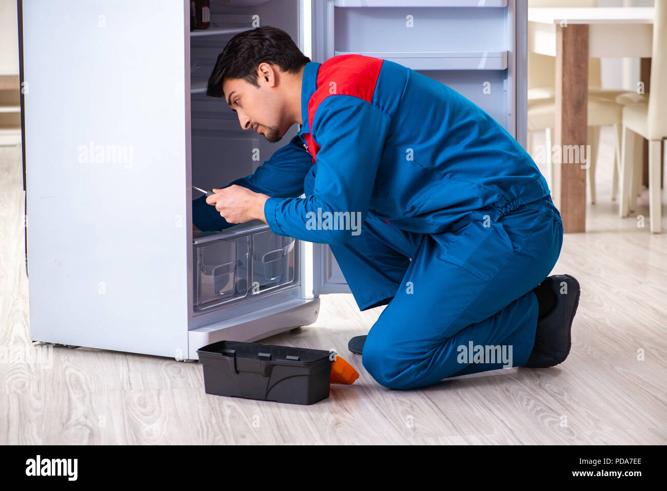 Man repairing fridge with customer Stock Photo - Alamy