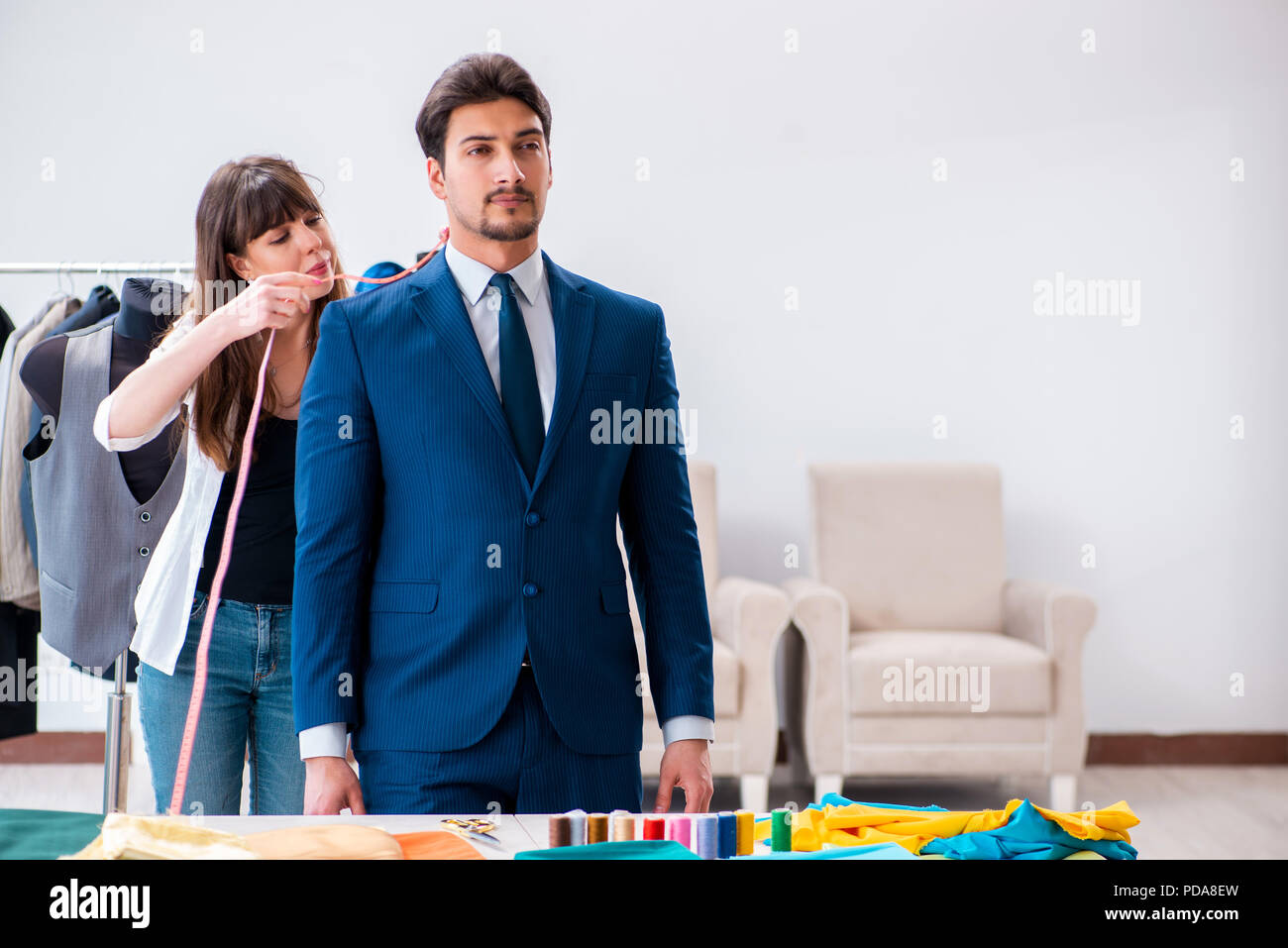 Professional tailor taking measurements for formal suit Stock Photo - Alamy