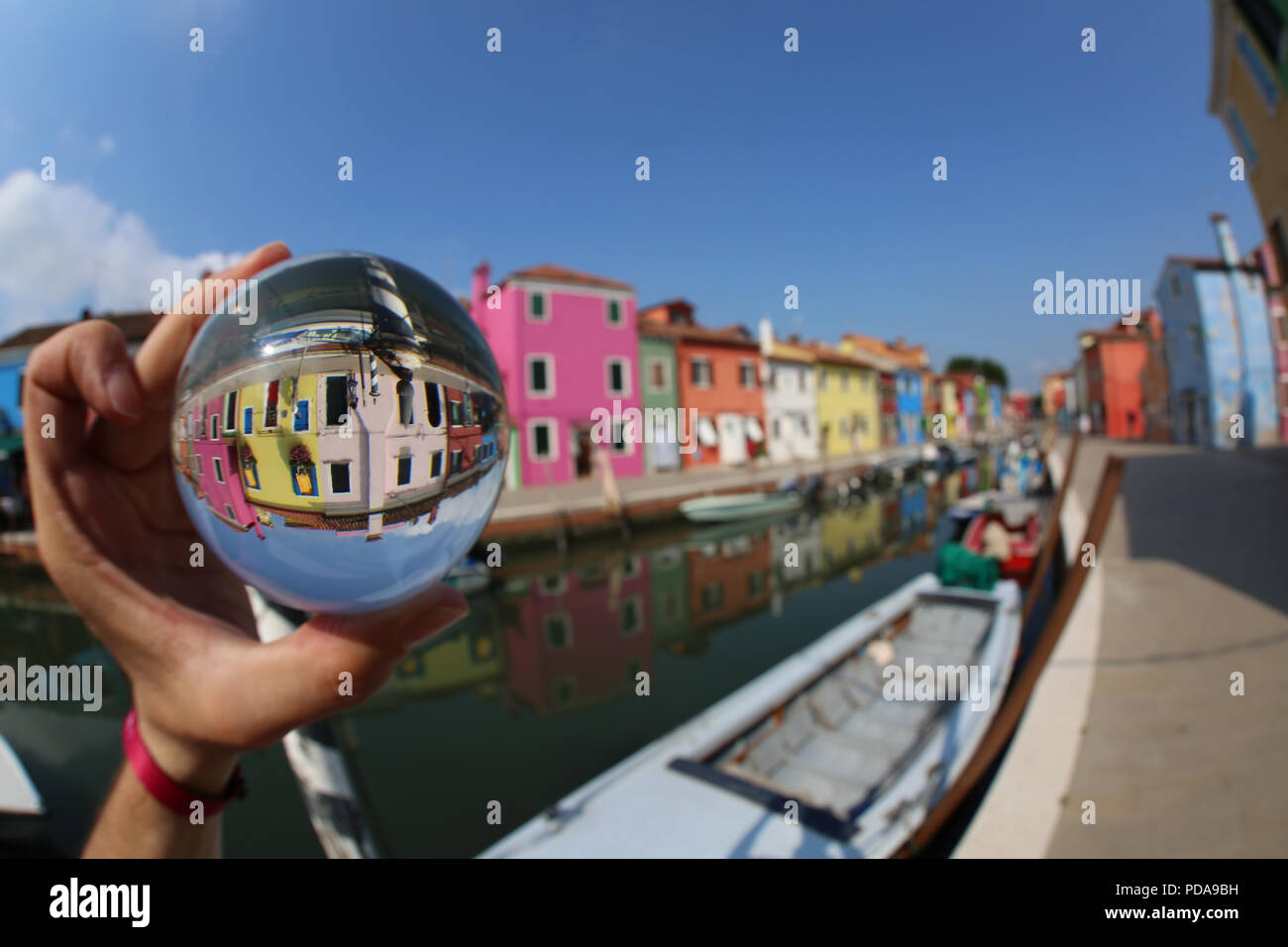 hand of the photographer holding a glass sphere on Burano Island near ...