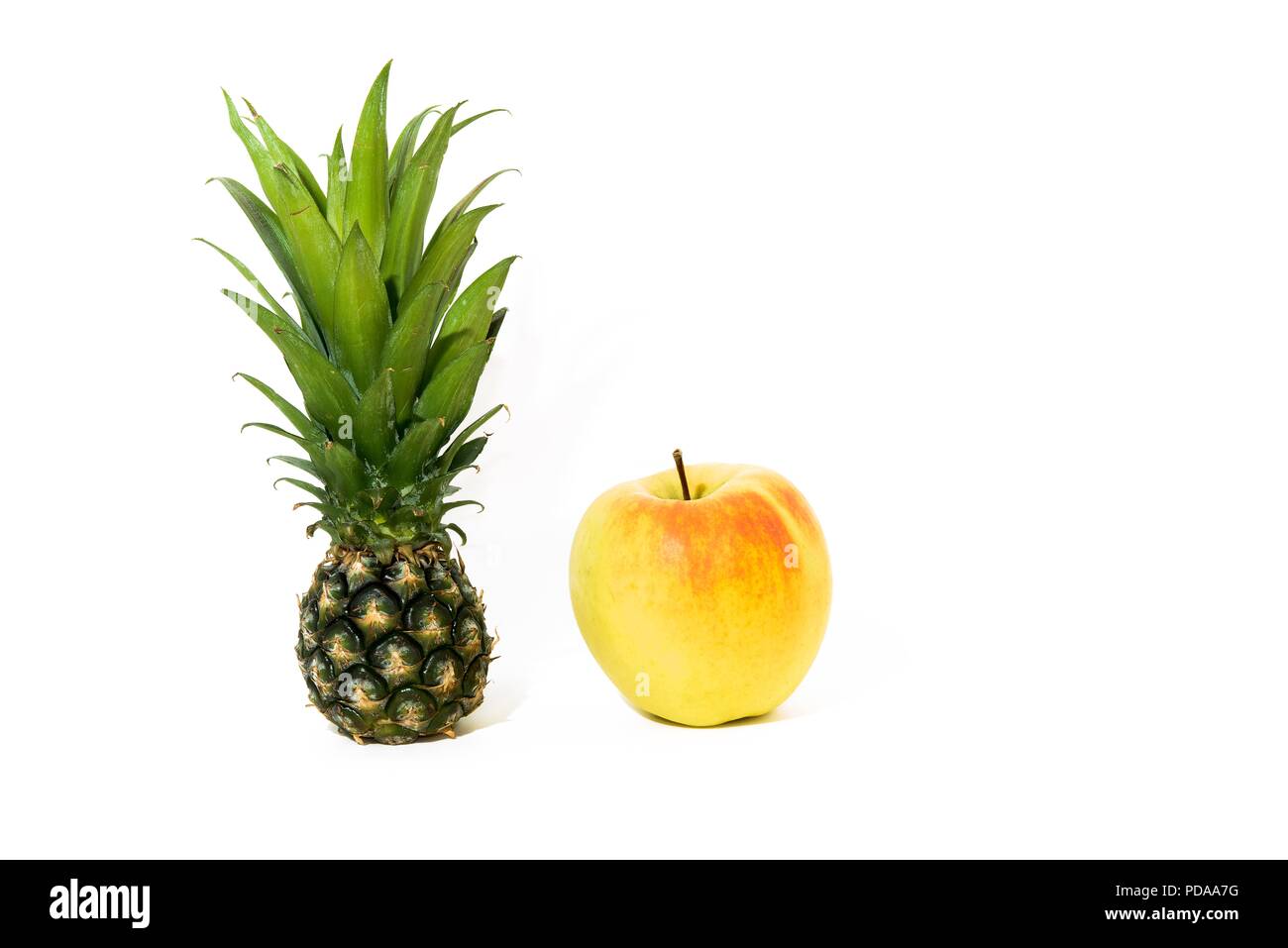Small pineapple with big apple Stock Photo - Alamy