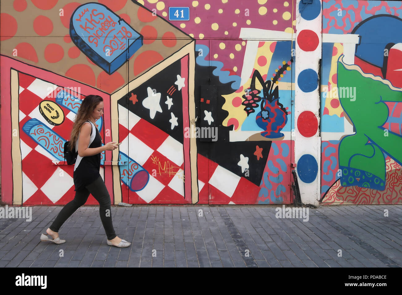 A pedestrian walks past a richly painted structure created by SICKBOY ...