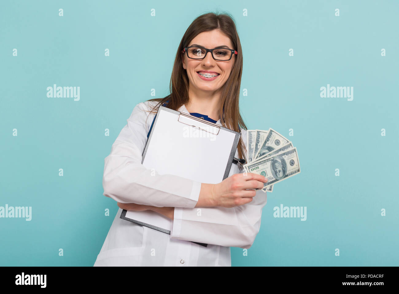 Female doctor with fan of money and clipboard Stock Photo - Alamy
