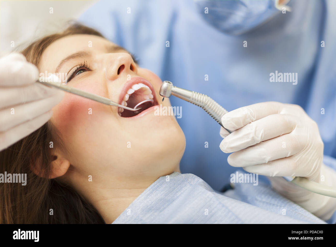 Dentist curing a female patient Stock Photo - Alamy