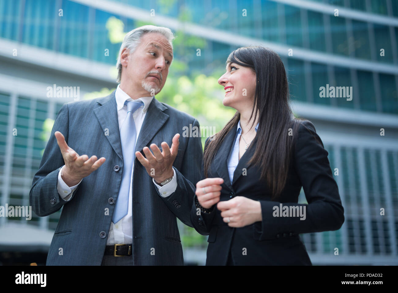 Business people having a conversation in front of their office Stock ...