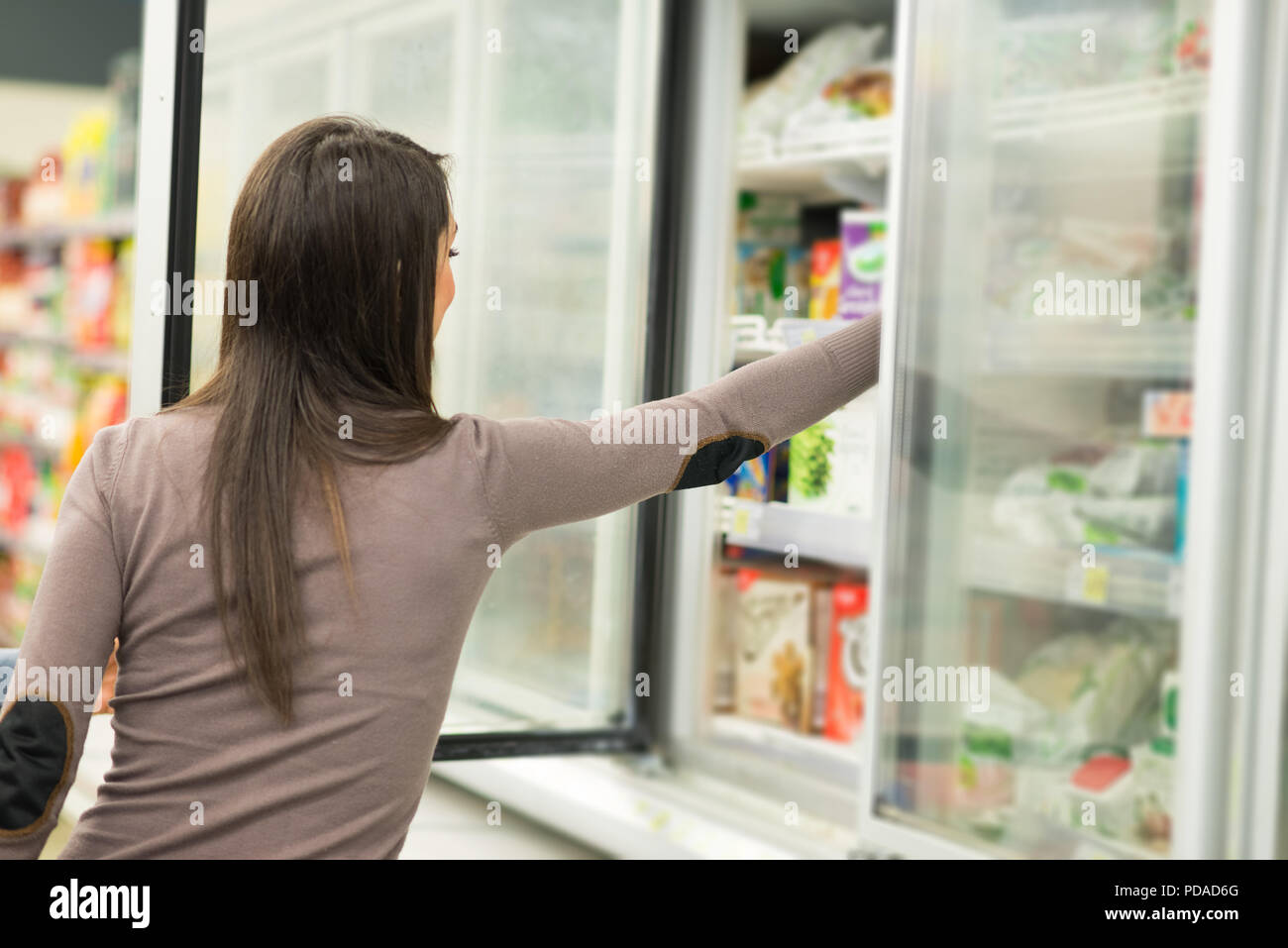 Woman taking deep frozen food from a freezer in a supermarket Stock ...