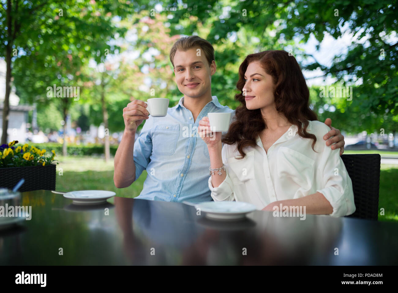 Young couple drinking tea together outdoor Stock Photo - Alamy