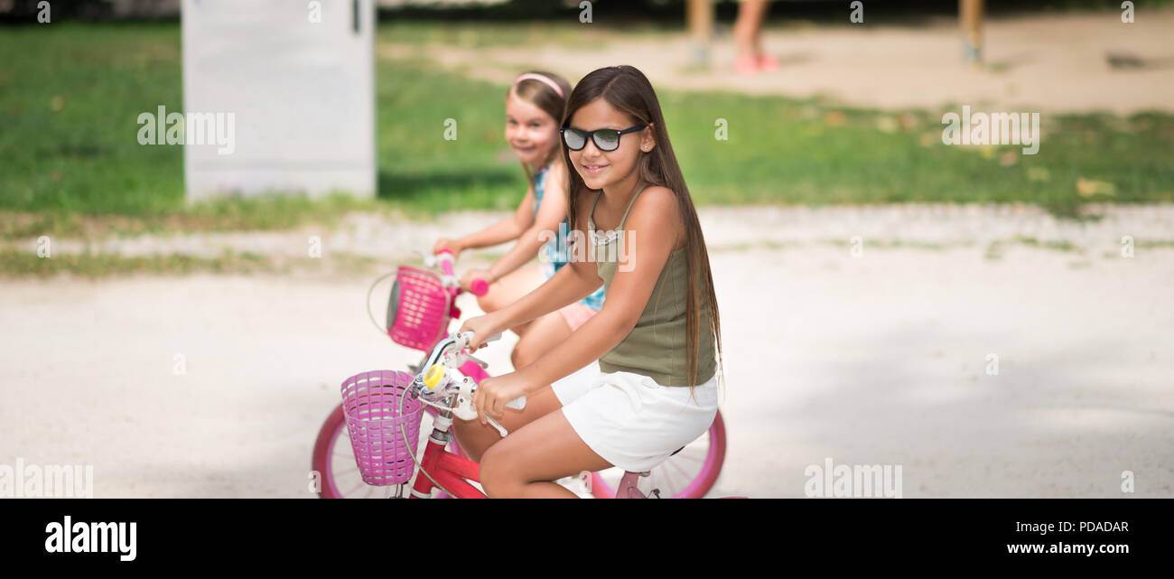 Happy beautiful children riding on their bike Stock Photo - Alamy