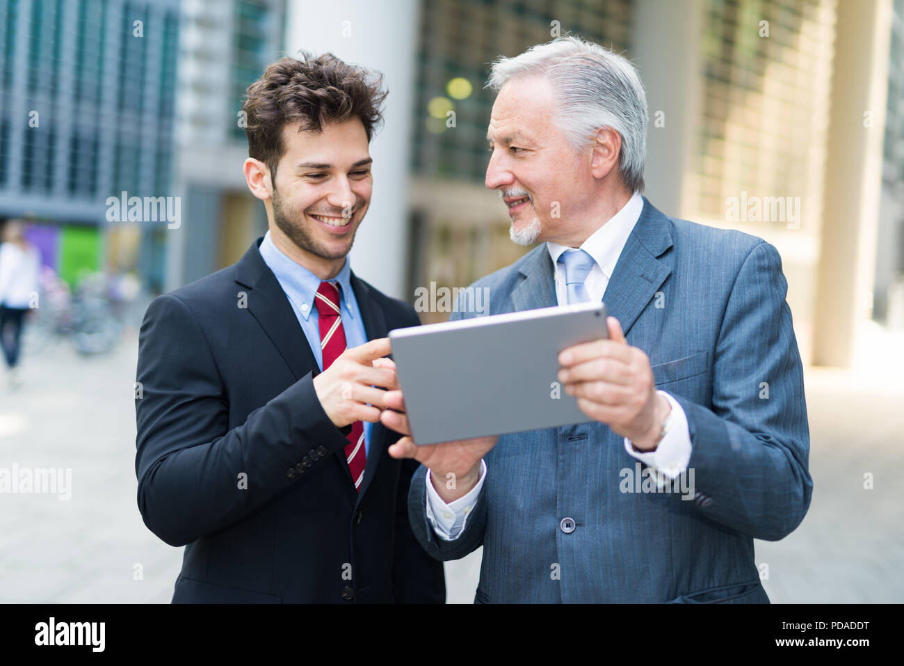Business people using a tablet together Stock Photo - Alamy