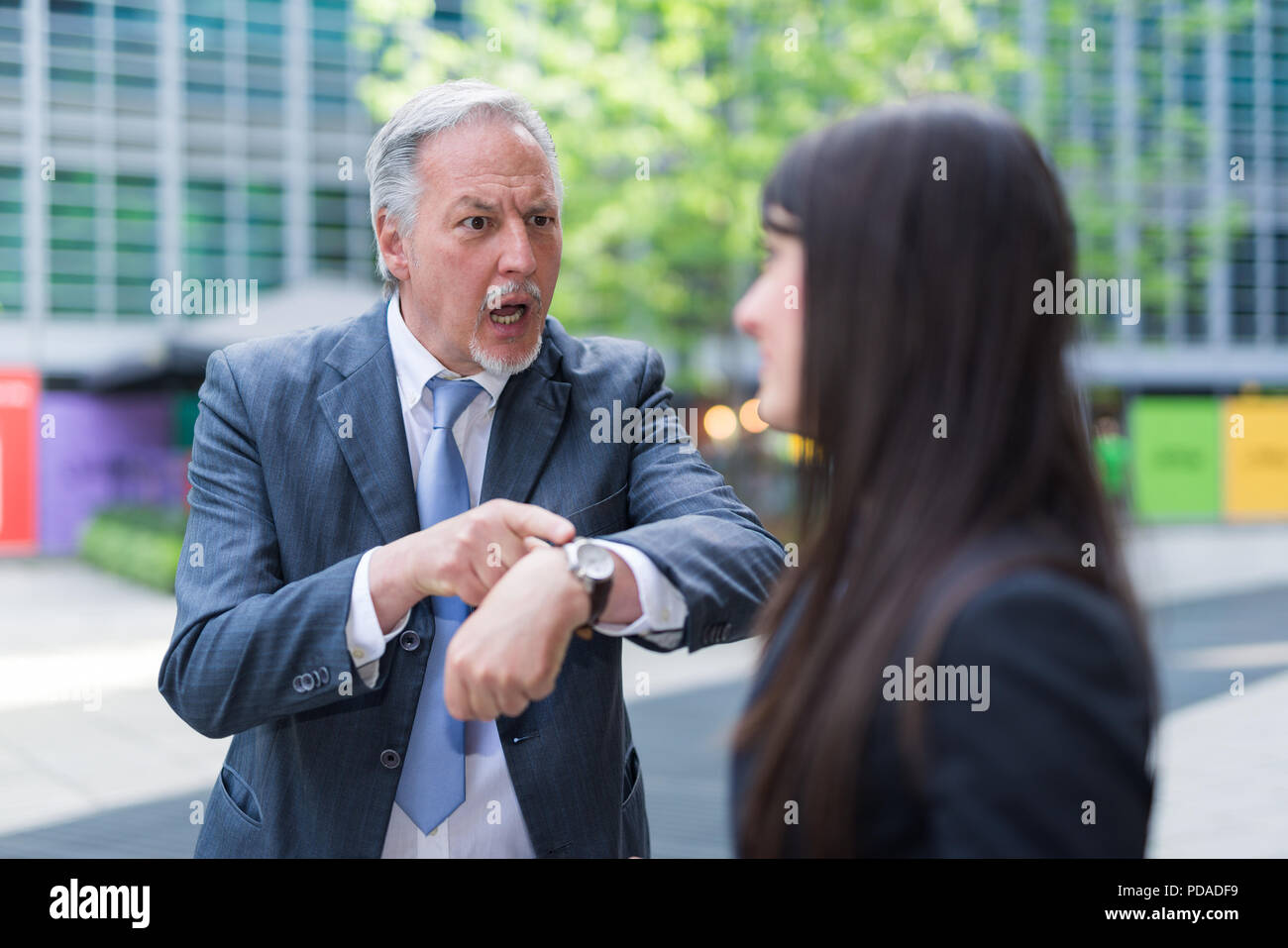 Boss scolding an employee for being late Stock Photo - Alamy