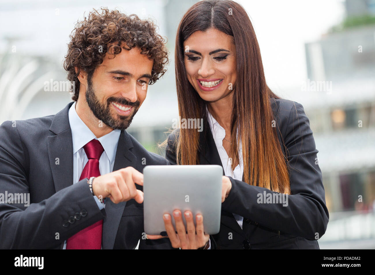 Business people using a tablet together Stock Photo - Alamy