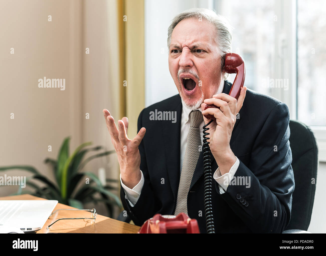 Angry businessman yelling on the phone Stock Photo - Alamy