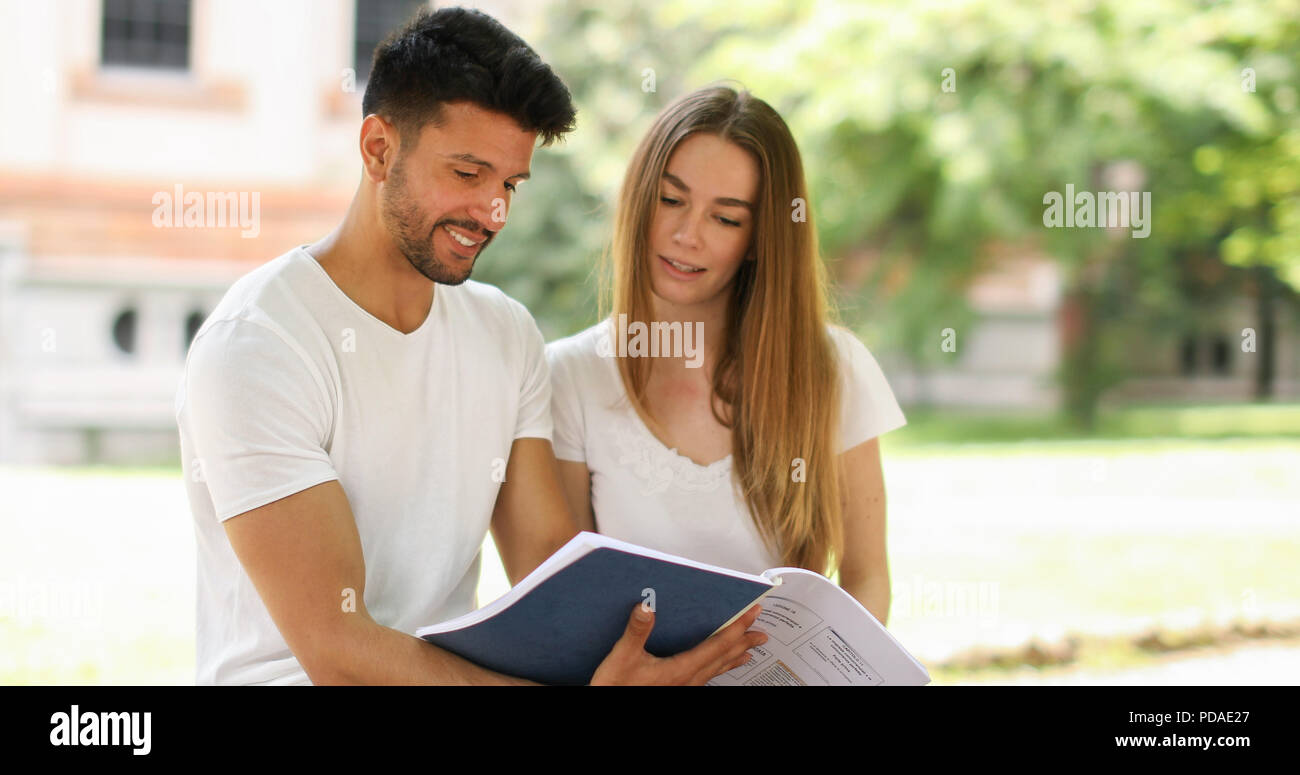 Two students studying together sitting on a bench outdoor Stock Photo ...