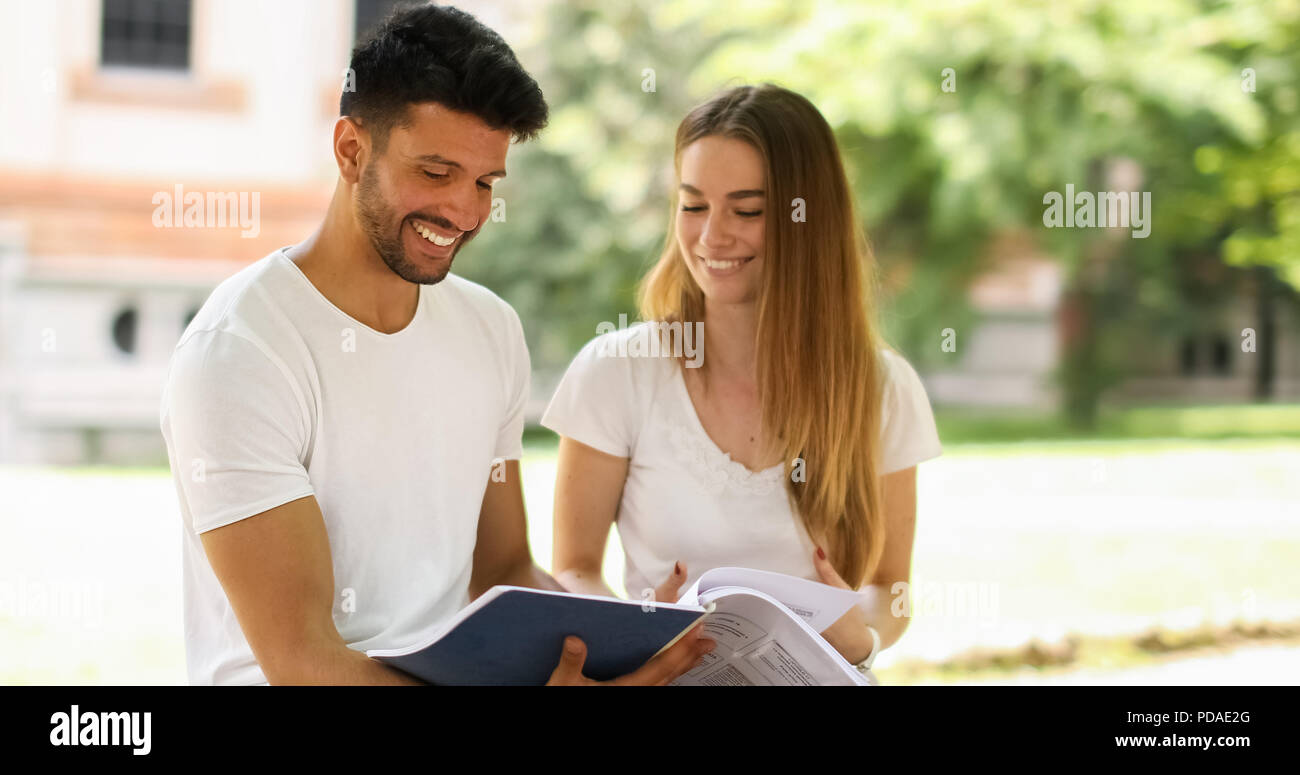 Two students studying together sitting on a bench outdoor Stock Photo ...