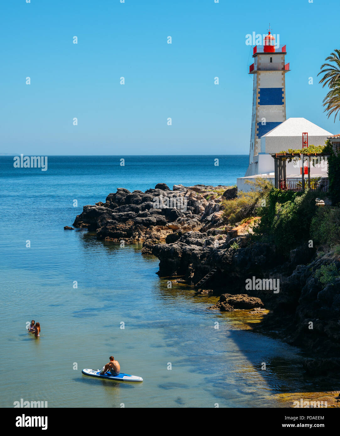 View of Santa Marta lighthouse and tourists relaxing on the water on a ...
